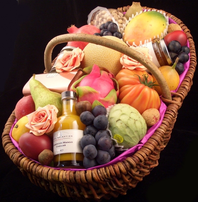 Fruitmand met fruit, wijn, chocolade en bonbons.